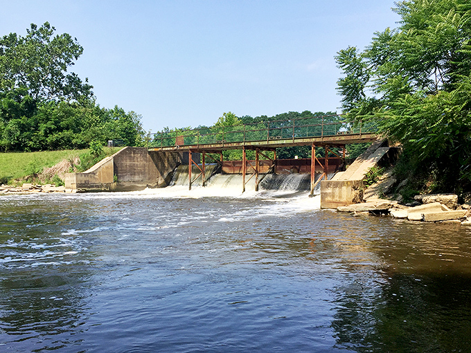 The dam creates a perfect waterfall moment, nature and engineering in a rare peaceful negotiation that benefits the scenery.