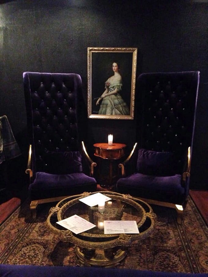 Royal purple thrones await discerning guests, offering a touch of nobility to your evening of sophisticated imbibing under the watchful gaze of vintage portraits.