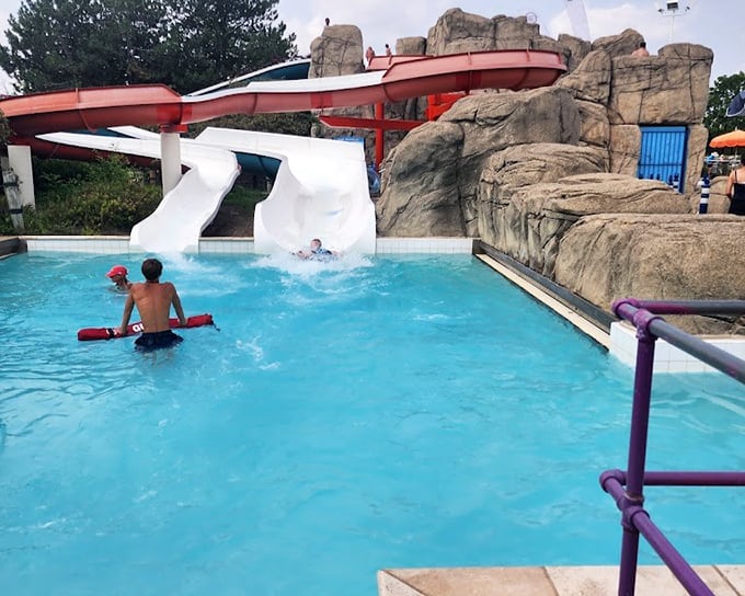 The landing zone where gravity concludes its watery negotiation with thrill-seekers.