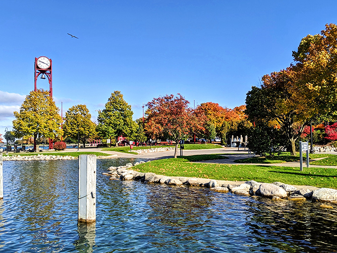 Pennsylvania Park's iconic clock tower stands amid autumn splendor, where water meets greenspace in the heart of downtown.
