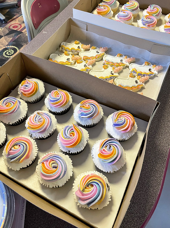 Colorful cupcakes with swirling frosting peaks stand at attention, their duck-shaped companions adding whimsy to any celebration.
