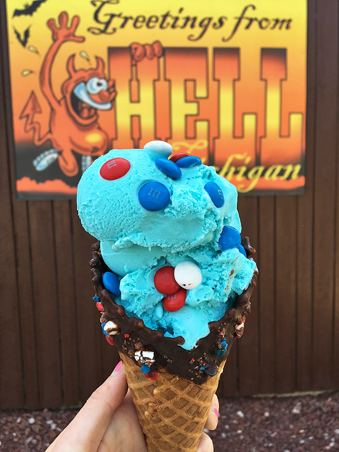 Blue ice cream studded with colorful M&Ms against a "Greetings from Hell" backdrop. The devil is truly in these delicious details.