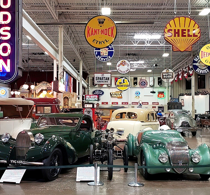 The museum's interior showcases automotive artistry from every angle, with vintage signage adding authentic atmosphere to this mechanical wonderland.