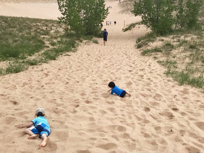 Young adventurers demonstrate the proper technique for descending a dune: face-first with maximum giggling. Adults should take notes.