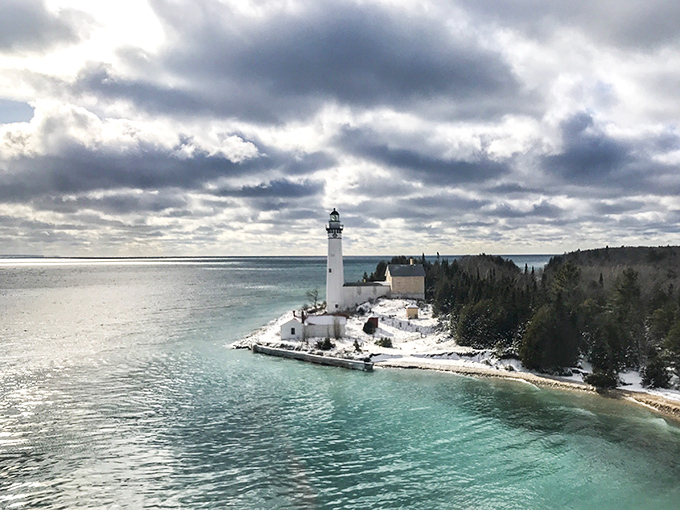 Lighthouse view from afar: Even in winter's embrace, the South Manitou Lighthouse stands defiant against the elements, a snow-capped guardian of the shipping lanes.