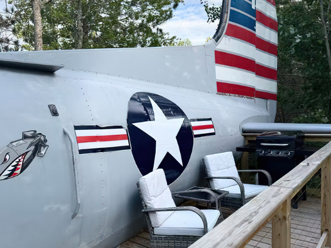 The plane's tail section features classic military markings, with outdoor seating for enjoying Wisconsin's natural beauty.