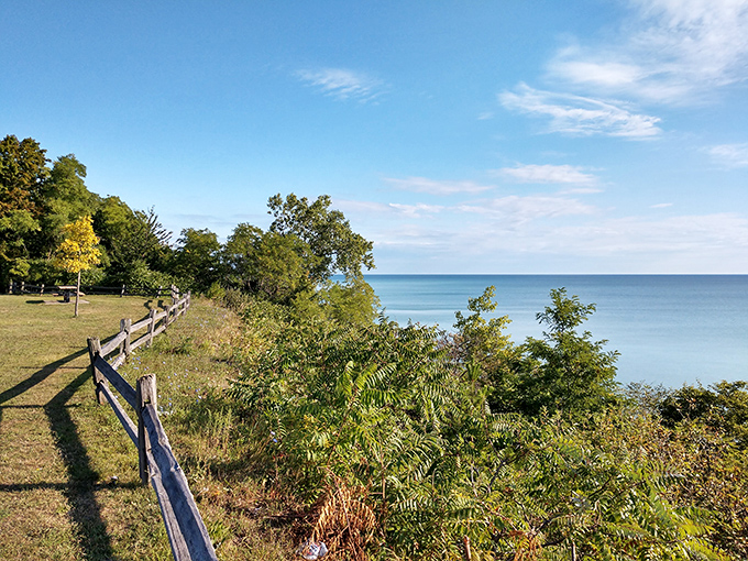 The rustic fence frames a view worth a thousand postcards, where the blue horizon meets the sky in perfect harmony.