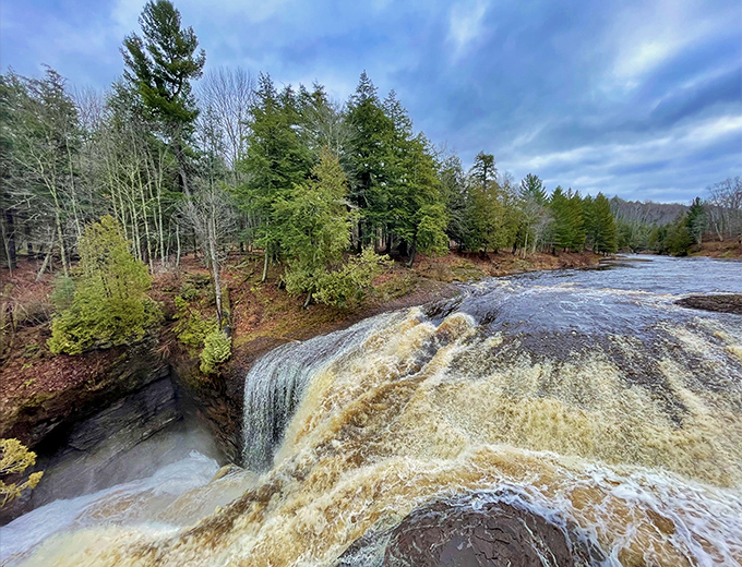 Postcard-perfect moment captured: The falls plunge dramatically over ancient volcanic rock, creating a scene that no filter could possibly improve.