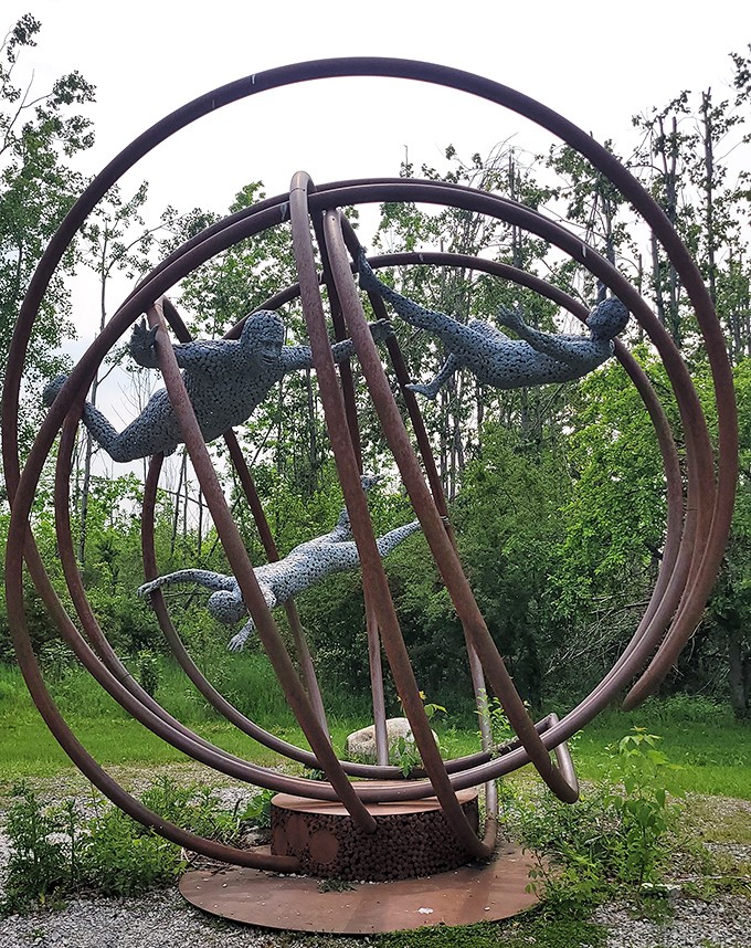 These metallic acrobats seem frozen mid-somersault through giant rings, proving that even iron figures need to let loose and have fun sometimes.