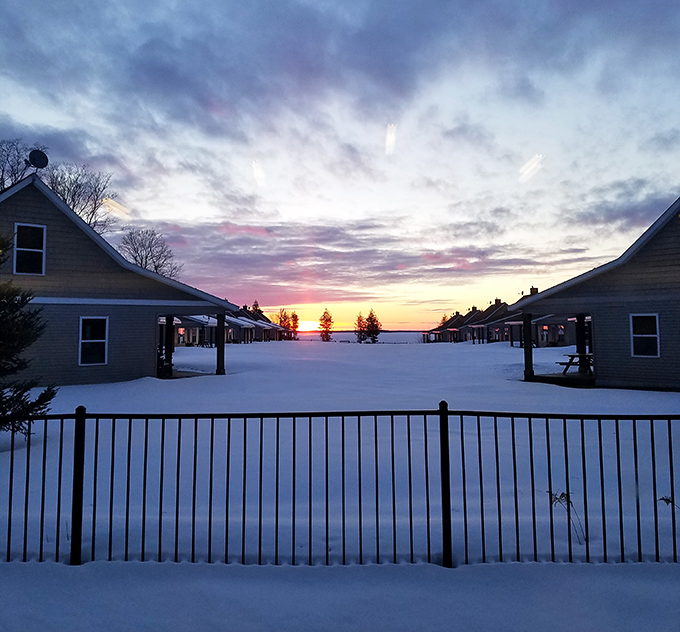 Winter wonderland: Snow transforms Pine Bluff into a postcard-perfect scene where cabin lights glow warmly against the frosty landscape.