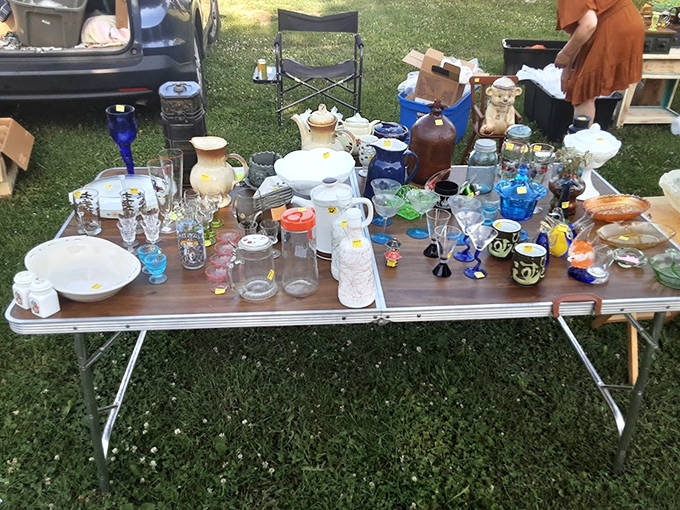 Domestic archaeology display: Vintage glassware and pottery tell stories of dinner parties past, each piece waiting for a second chance to shine on new tables.