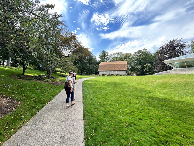 Under a sky that belongs in a Renaissance painting, visitors stroll toward a rustic barn, proving that sometimes the best landscaping is simply letting nature do its thing.