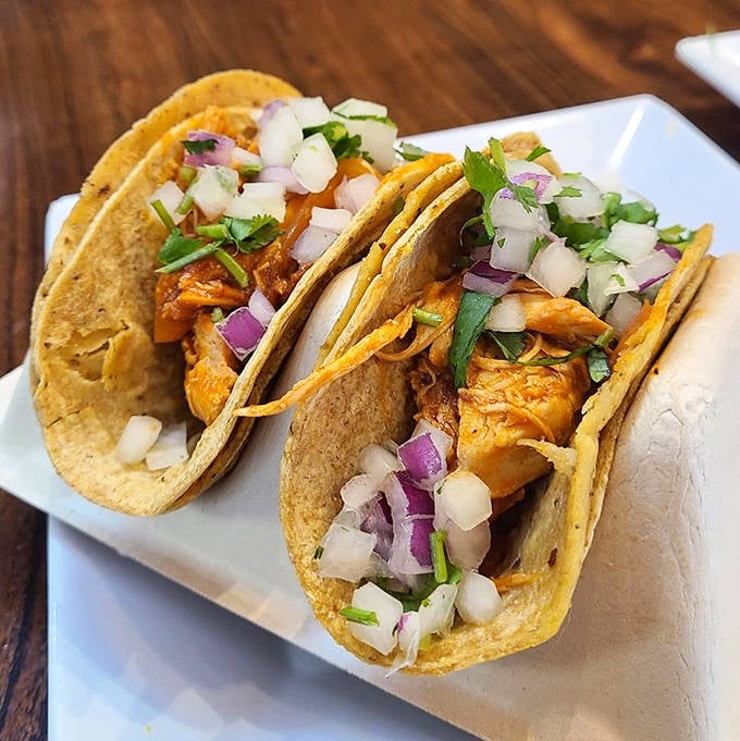 These chicken tacos arrive dressed traditionally &ndash; just meat, cilantro, and onion on fresh corn tortillas &ndash; proving sometimes simplicity is the ultimate sophistication.