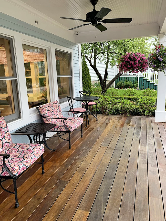 Covered Front Porch Seating: Pink floral cushions brighten wooden chairs on this shaded porch – prime real estate for fudge-eating and people-watching.