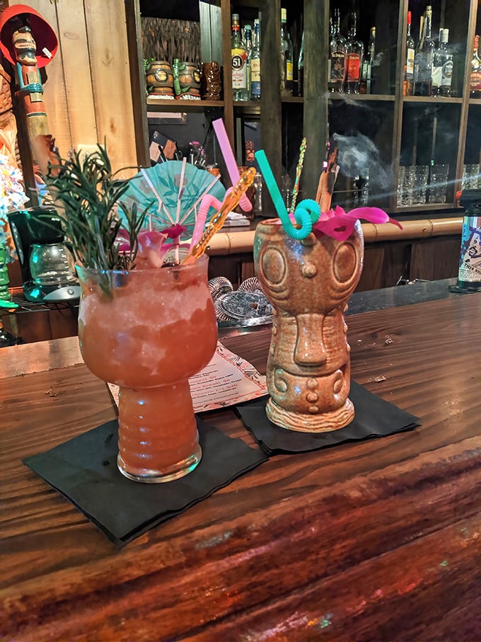 Tiki mugs stand at attention like a colorful army, each one promising to transform ordinary evenings into extraordinary memories.