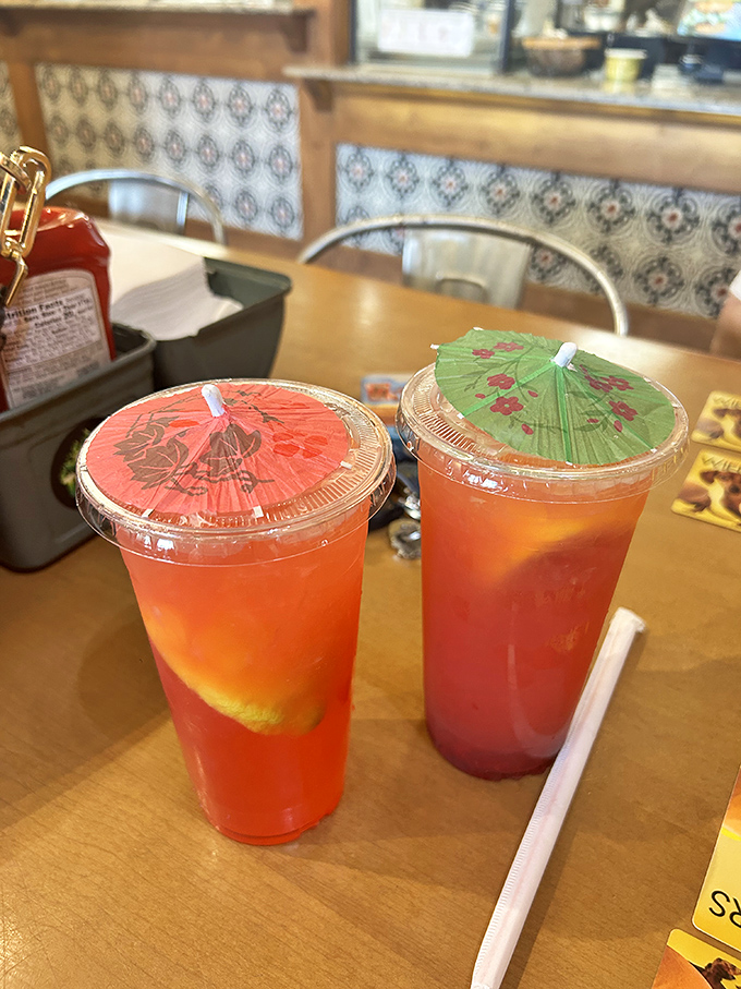 These colorful lemonades topped with playful paper umbrellas aren't just refreshing &ndash; they're summer in a cup, ready to complement your sandwich adventure.