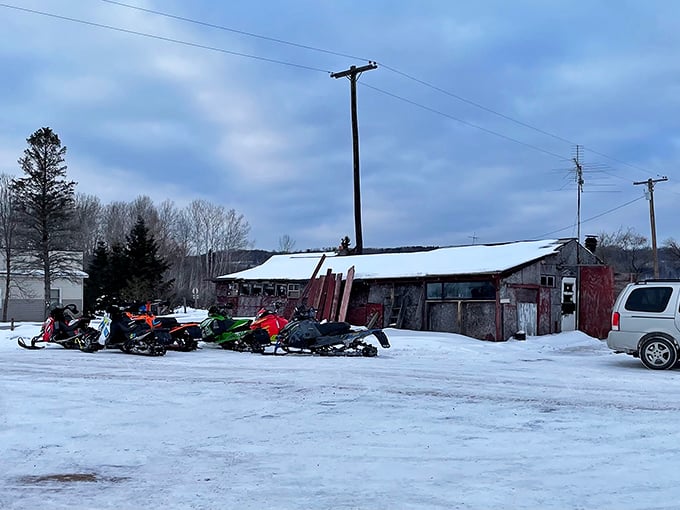 Winter transforms the bar into a snowmobiler's haven, with colorful sleds parked outside like modern-day horses at a frontier saloon.