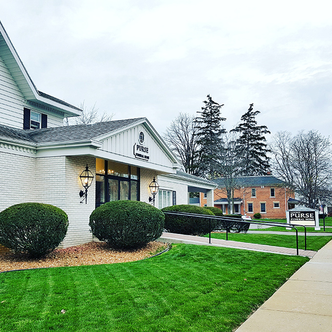 A stately white funeral home stands dignified against the landscape, somehow making the business of goodbye look warm and inviting.