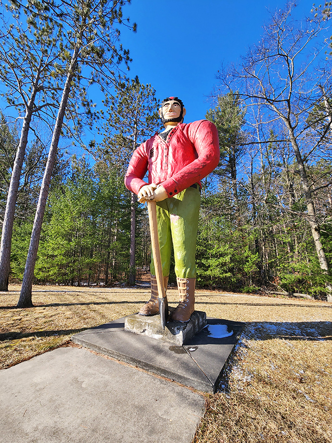 The giant lumberjack's weathered paint tells stories of Michigan winters and summers, yet his stance remains proud and unwavering.