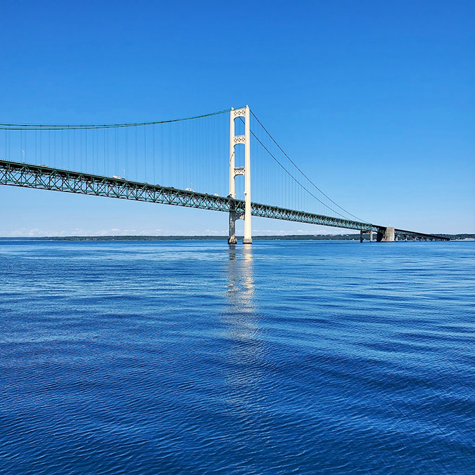 The bridge's distinctive ivory towers and green span create Michigan's most recognizable silhouette against the deep blue Straits waters.