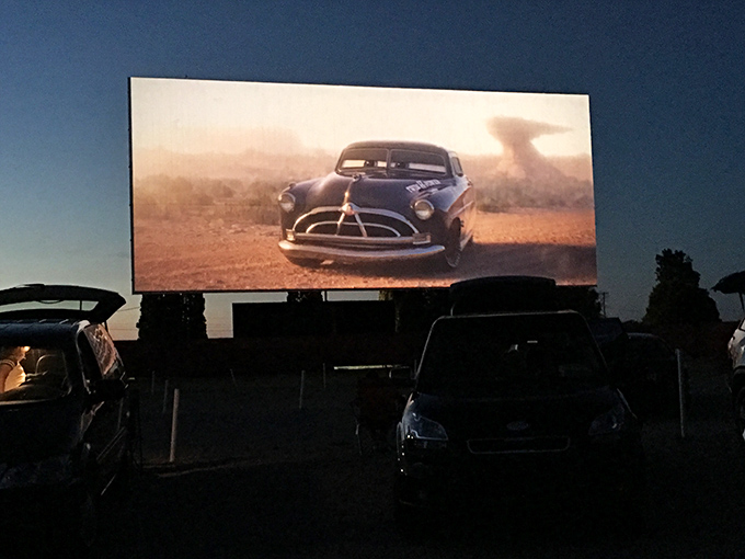 A vintage car races across the massive screen while modern vehicles sit in reverent silence &ndash; past and present sharing popcorn under Michigan's inky canvas.