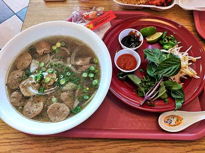 A steaming bowl of pho with all the traditional accompaniments. Fresh herbs and condiments transform this soup from simple to spectacular with each customized spoonful.