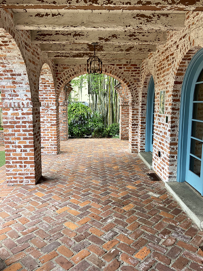 Brick arches frame views of bamboo gardens beyond, creating that indoor-outdoor flow that Floridians perfected long before it became a design trend.
