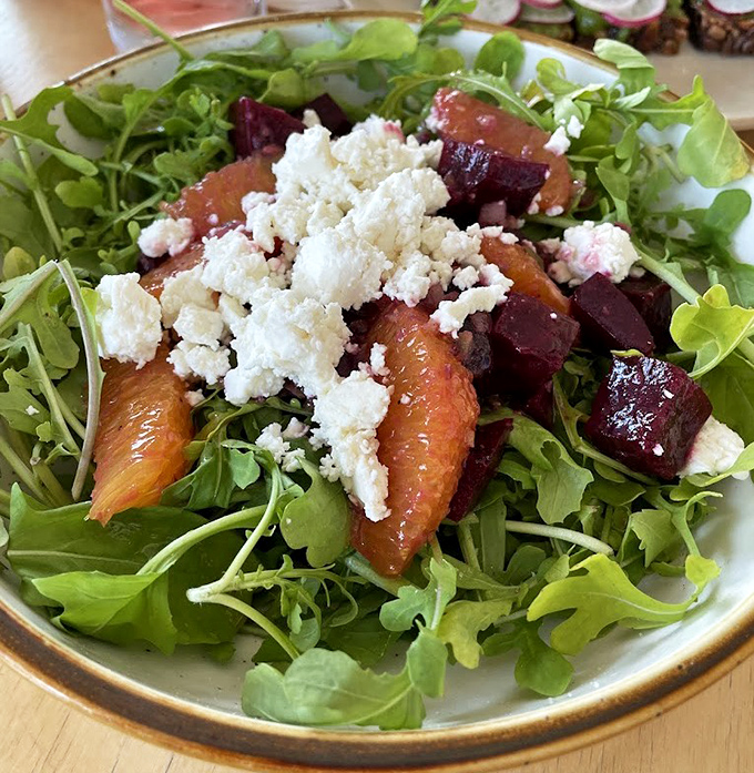A vibrant celebration of seasonal greens, where beets and citrus segments play hide-and-seek among peppery arugula.