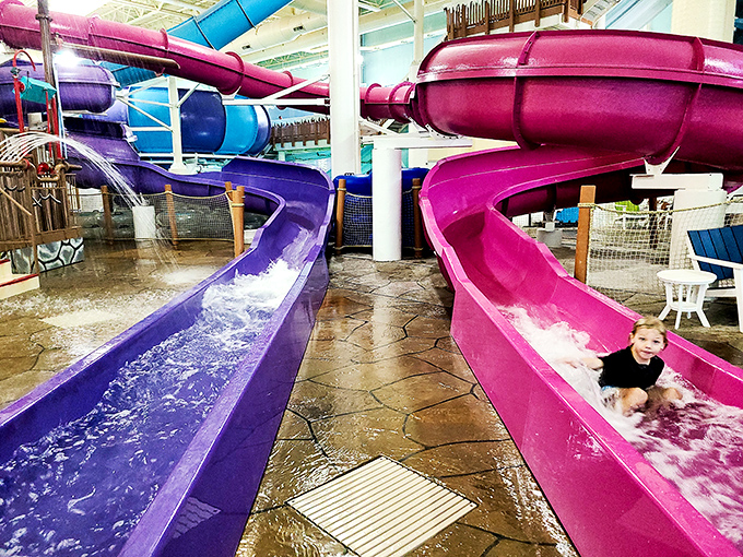 Vibrant purple and pink water slides twist and curve through the facility, promising exhilarating rides that end with satisfying splashdowns.