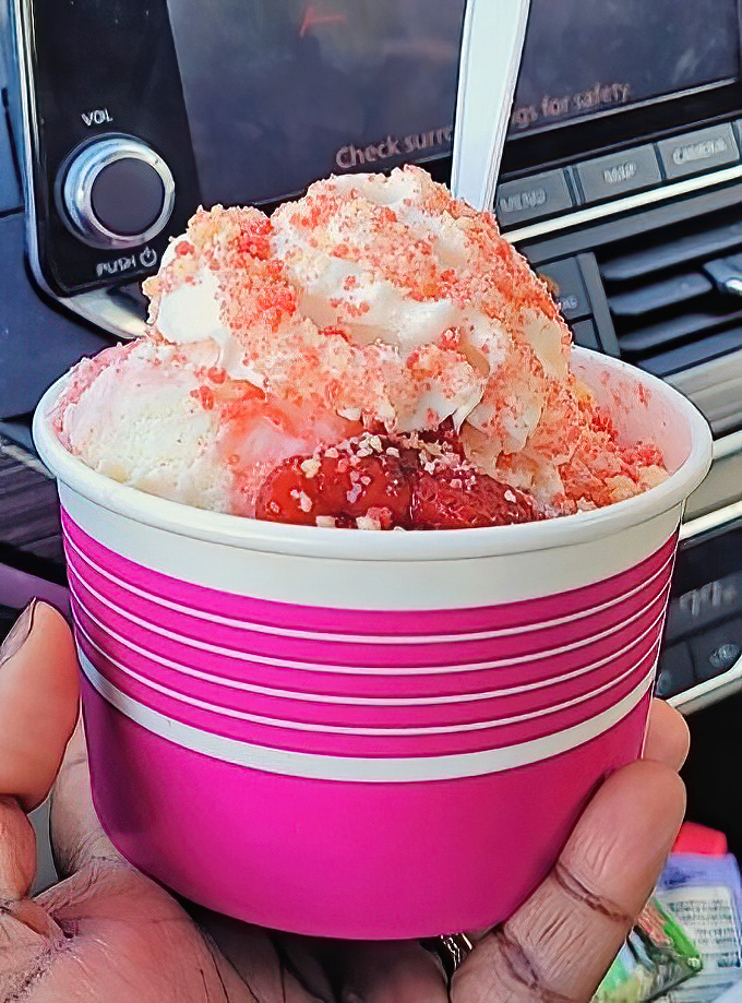 A strawberry cheesecake sundae that's worth every calorie &ndash; fresh berries, creamy ice cream, and sweet sauce creating a symphony in a cup.