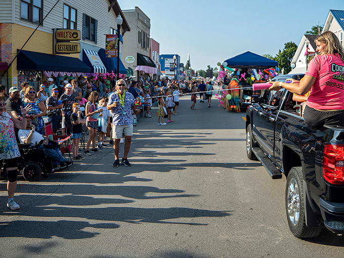 Main Street transforms into a tropical runway where locals line up for their annual dose of paradise, complete with beads and burger sightings.