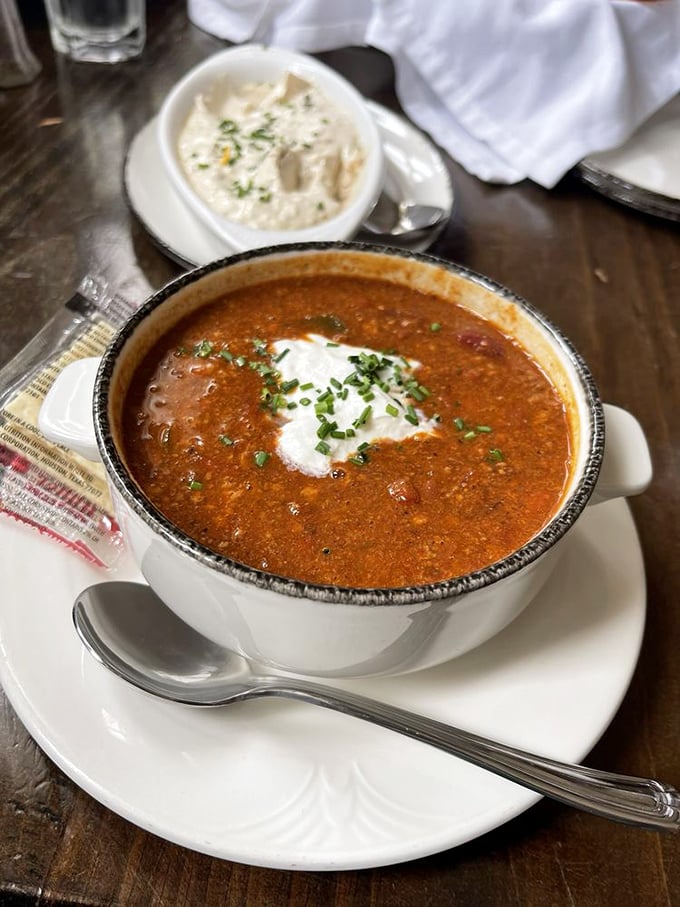 Venison chili brings frontier flavor to modern tables, the rich, hearty stew topped with a cooling dollop of sour cream and fresh chives.