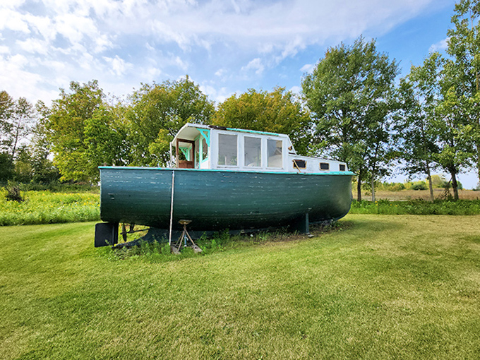 This vintage green boat rests permanently ashore, like a retired sailor who's swapped sea tales for lawn ornament status.
