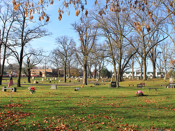 Majestic trees stand watch over the expansive grounds, their branches reaching skyward like nature's own memorial sculptures.