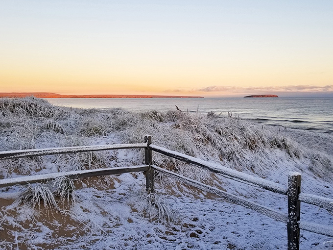 Winter transforms Au Train Beach into a frosted wonderland where Lake Superior's waters meet snow-dusted shores at dawn.