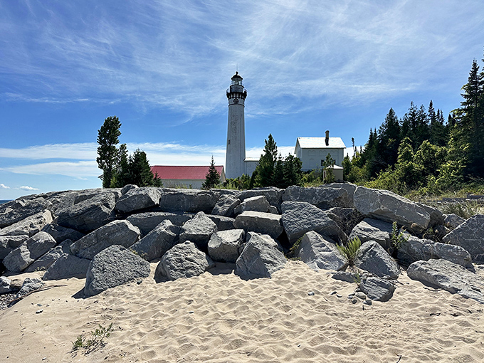 Another angle: Rising from rocky shores like Michigan's own coastal castle, the lighthouse commands respect from both land and water.