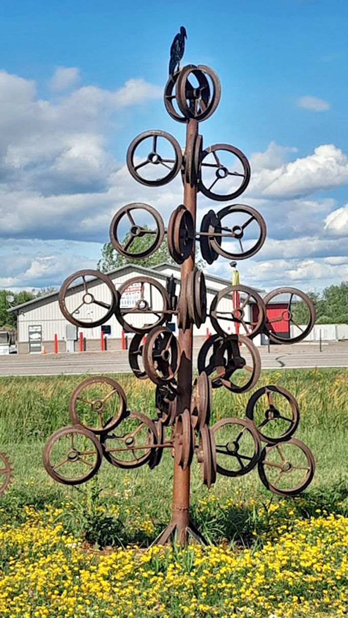 A mechanical tree blooms with bicycle wheels instead of leaves, spinning hypnotically in the Minnesota breeze like industrial pinwheels.