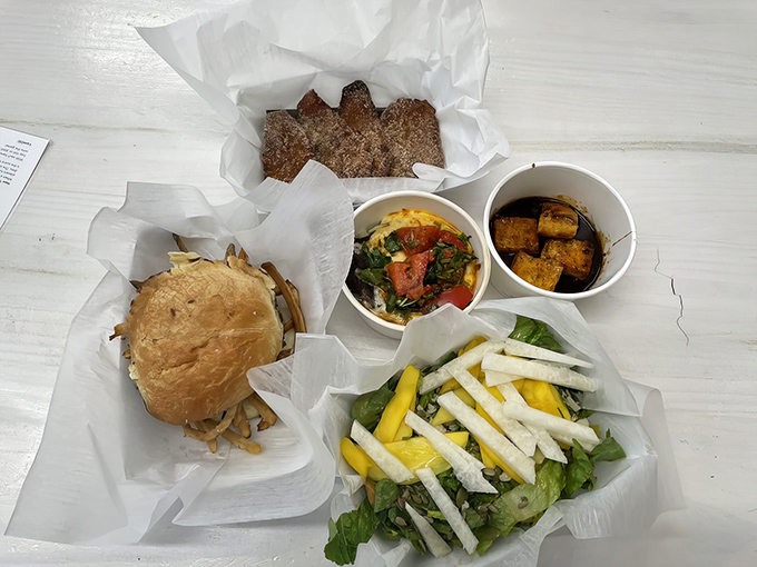 The full spread experience: crispy churros, a loaded frita, fresh salad, and those addictive plantain chips &ndash; a feast that spans the flavor spectrum.