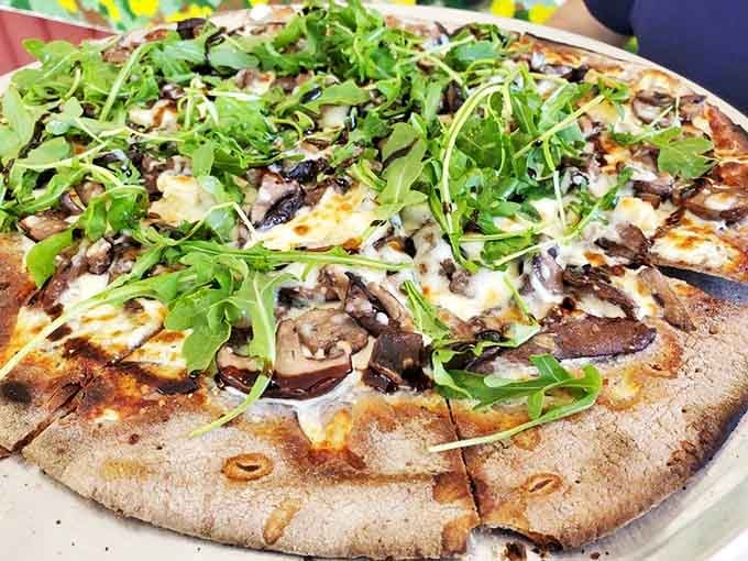 Mushroom pizza perfection: Earthy fungi and peppery arugula dance atop a perfectly charred crust that would make an Italian grandmother nod in approval.