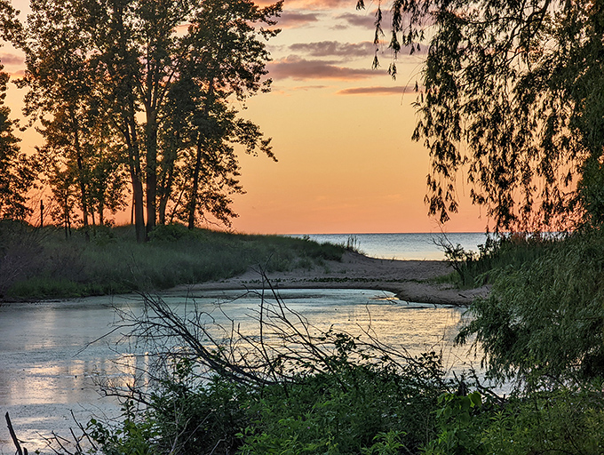 Nature's grand finale: sunset paints the sky in watercolor hues while reflecting perfectly on the still water's mirrored surface.