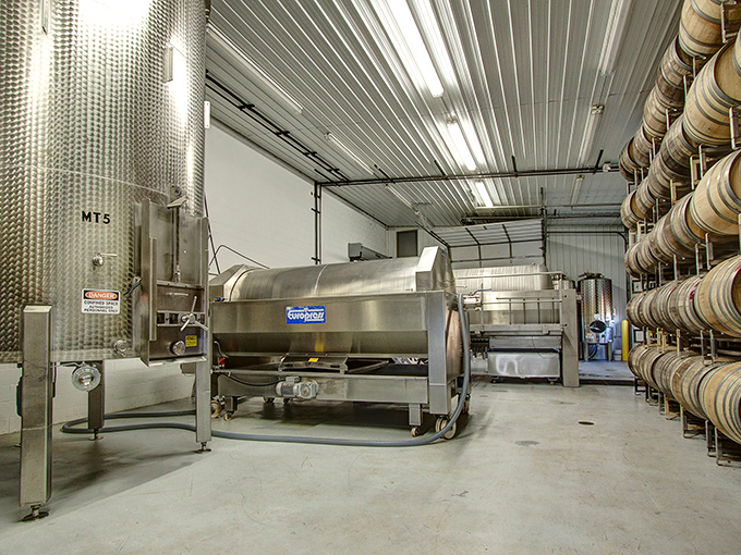 Behind the scenes in the production facility, where stainless steel tanks and oak barrels transform fruit into liquid poetry.