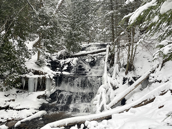 Winter transforms Wagner Falls into a crystalline wonderland, where flowing water and frozen sculptures create a magical contrast.