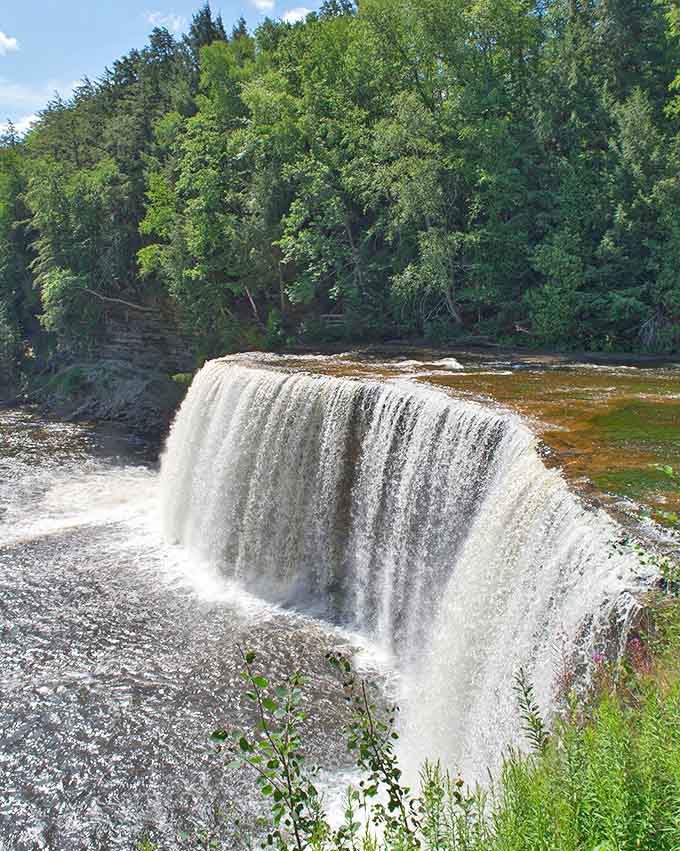 The mighty Upper Tahquamenon Falls thunders through Michigan's wilderness. The amber-colored water, stained by natural tannins, creates a unique and mesmerizing sight in any season.