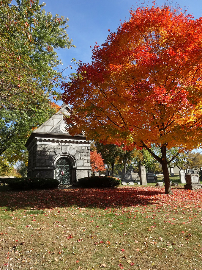 Autumn's fiery display creates a breathtaking backdrop for this stone mausoleum, proving that cemeteries can be places of spectacular beauty.