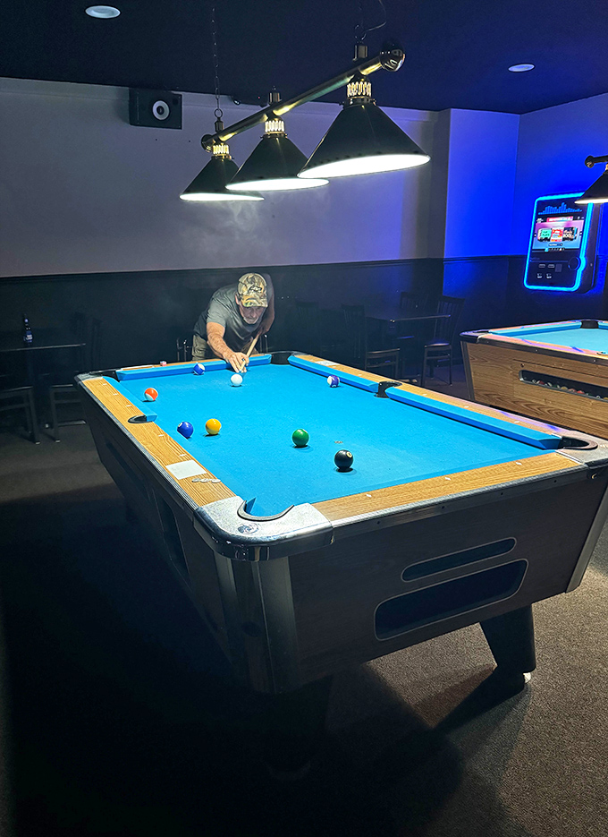Under focused pendant lighting, the billiards area offers a different kind of gaming challenge &ndash; one where precision and patience replace button-mashing frenzy.