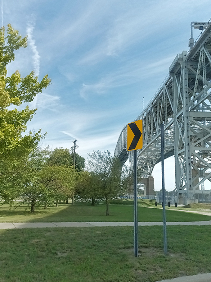 The trail winds beneath the towering bridge, where directional signs point the way but can't possibly prepare you for the beauty that awaits.