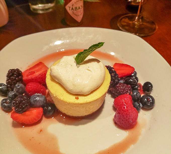 Dessert that doesn't just end the meal but crowns it – fresh berries surrounding a cheesecake island in a sea of sweet sauce.