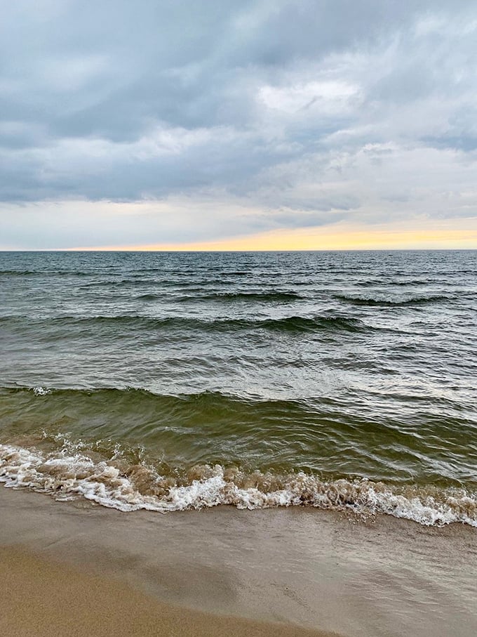 Lake Michigan's gentle waves create a hypnotic rhythm against the shore, nature's own meditation soundtrack for beach visitors.