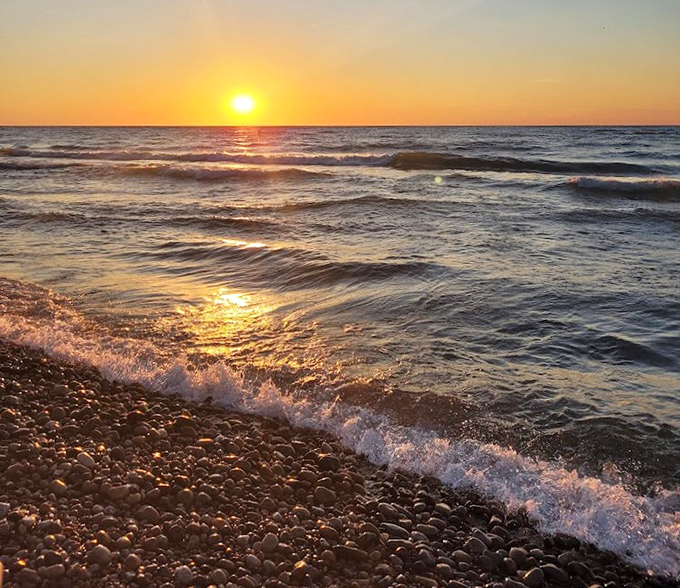Shoreline Sunset: Lake Michigan puts on its nightly magic show, turning water to liquid gold as the sun takes its final bow.