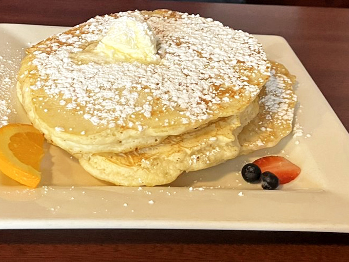 Sweet cream pancakes so fluffy they practically hover above the plate – with fruit garnish pretending this is somehow health food.
